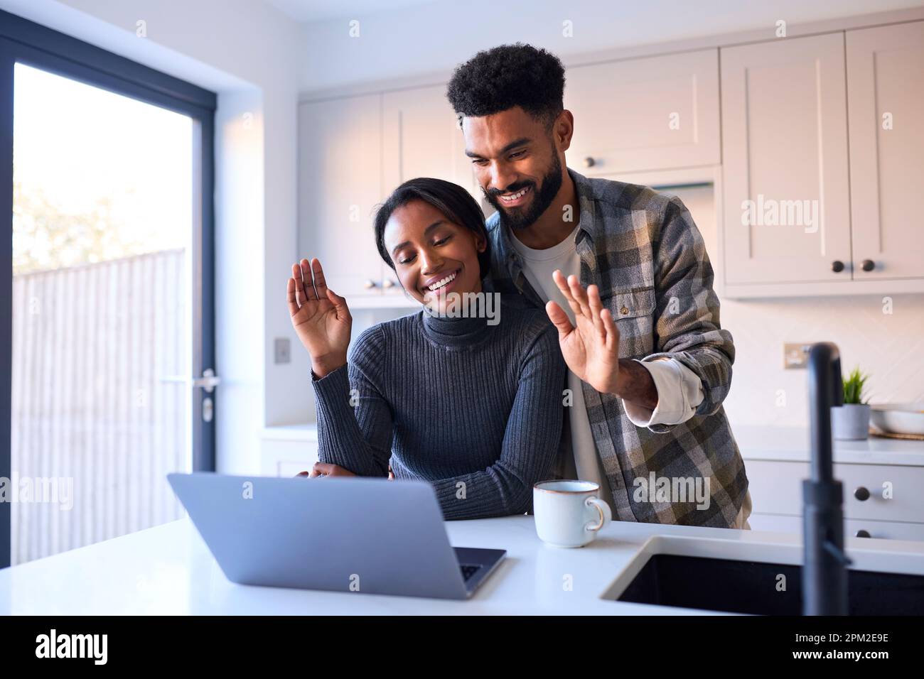 Couple At Home Making Video Call On Laptop On Counter In Kitchen ...