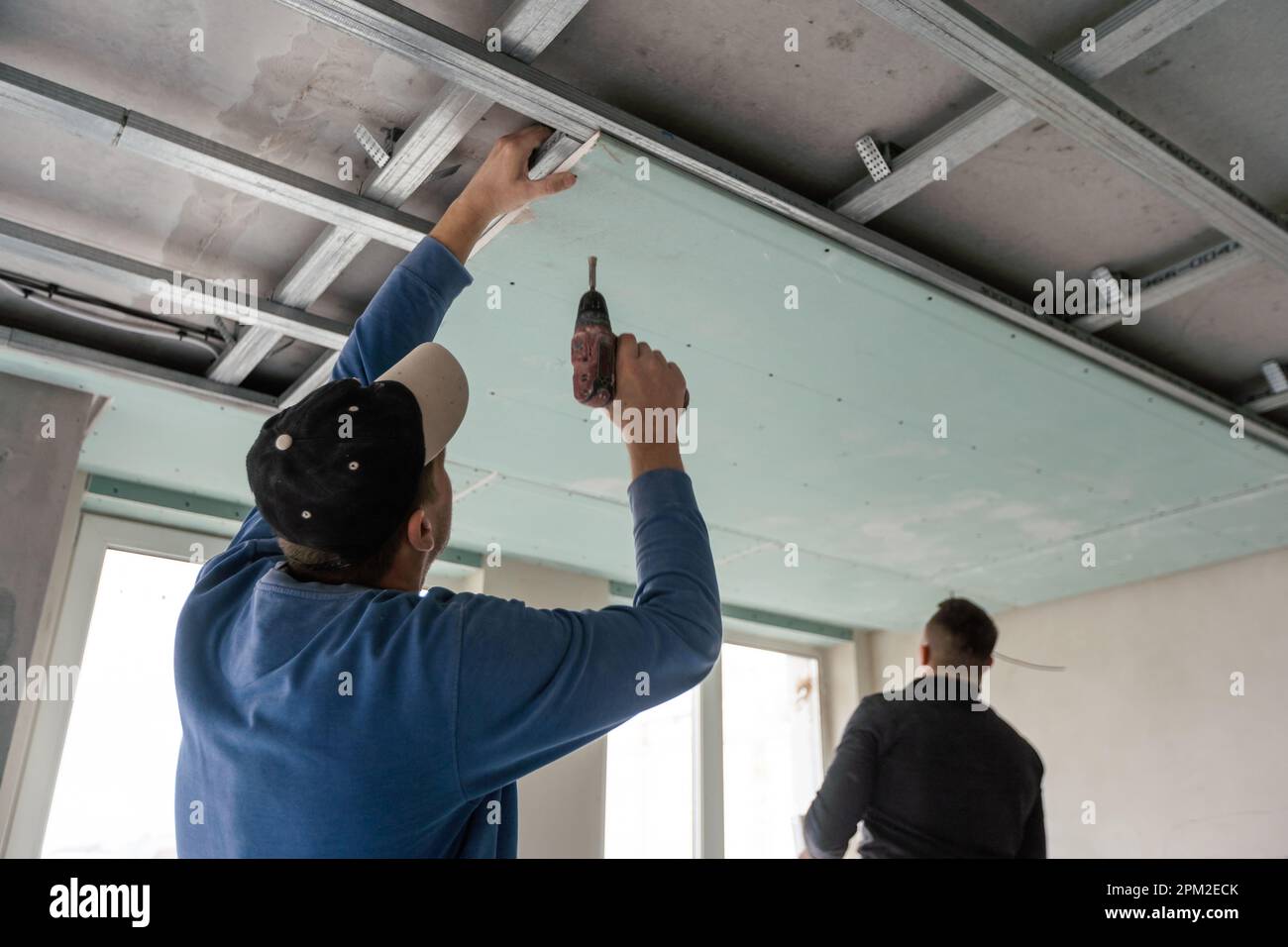 Construction worker installation ceiling work Stock Photo - Alamy
