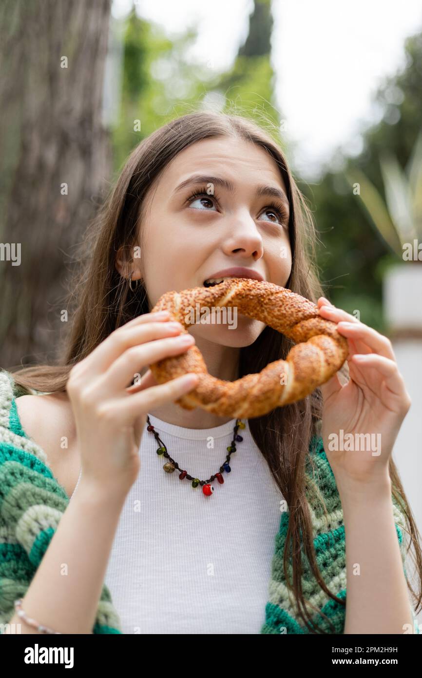Brunette woman eating traditional turkish simit bread in Istanbul,stock ...