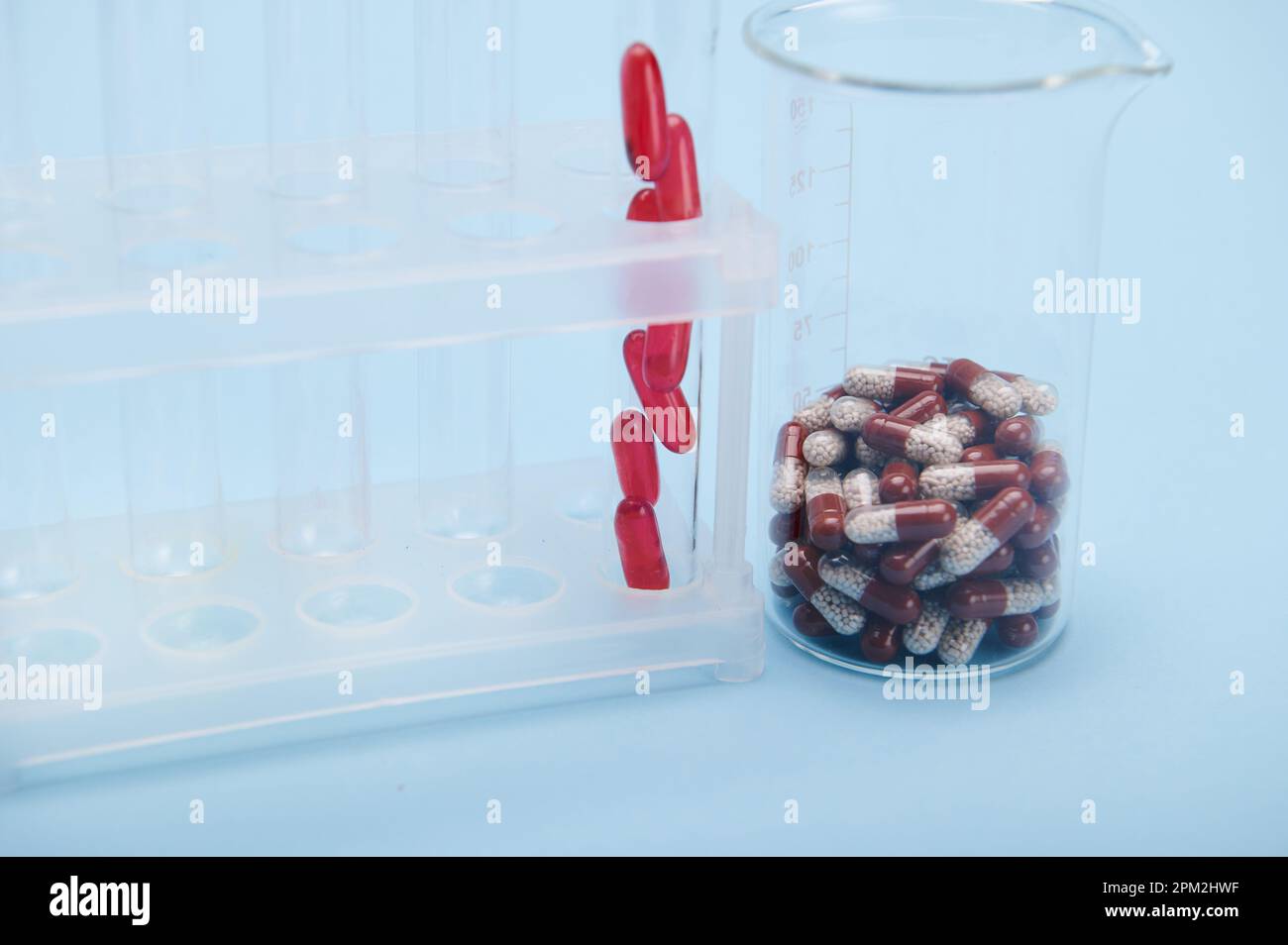 Graduated lab beaker with translucent capsules with medical granules ...