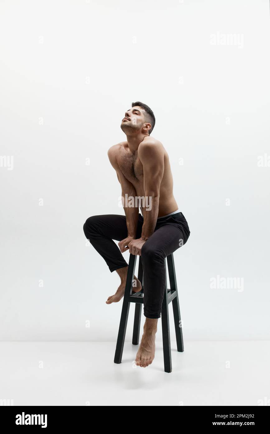 One handsome pensive man sitting on chair, dreaming and looking up over ...