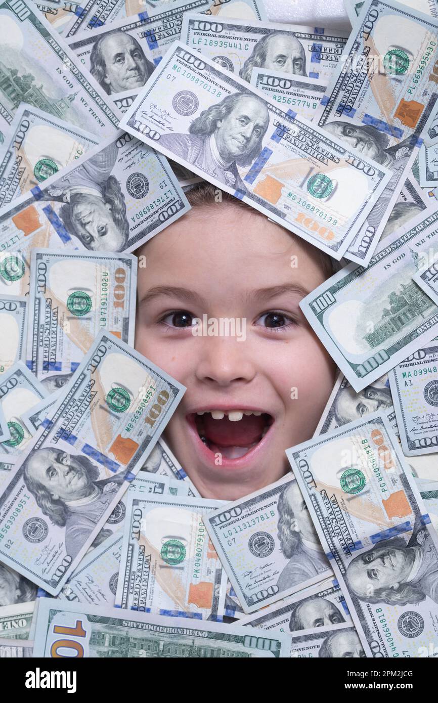 Funny child with fun face with money. Kid peeking out of dollar bills ...