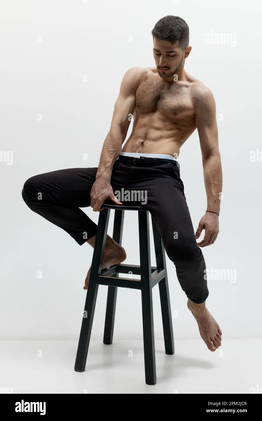 One young stylish handsome guy posing over white studio background ...