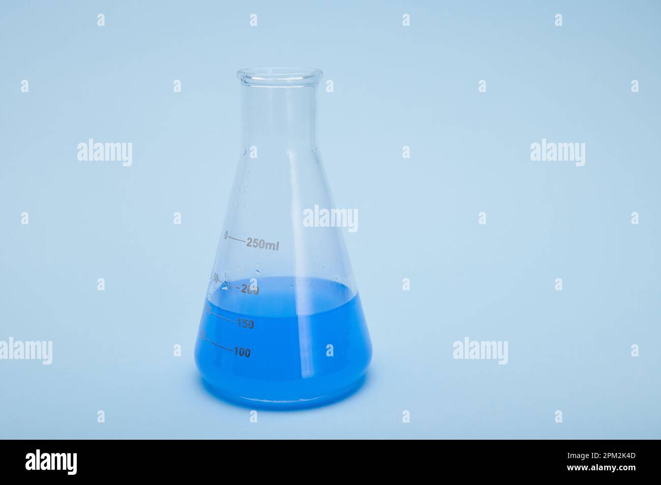Still life with graduated flat bottomed lab flask with blue fluid ...
