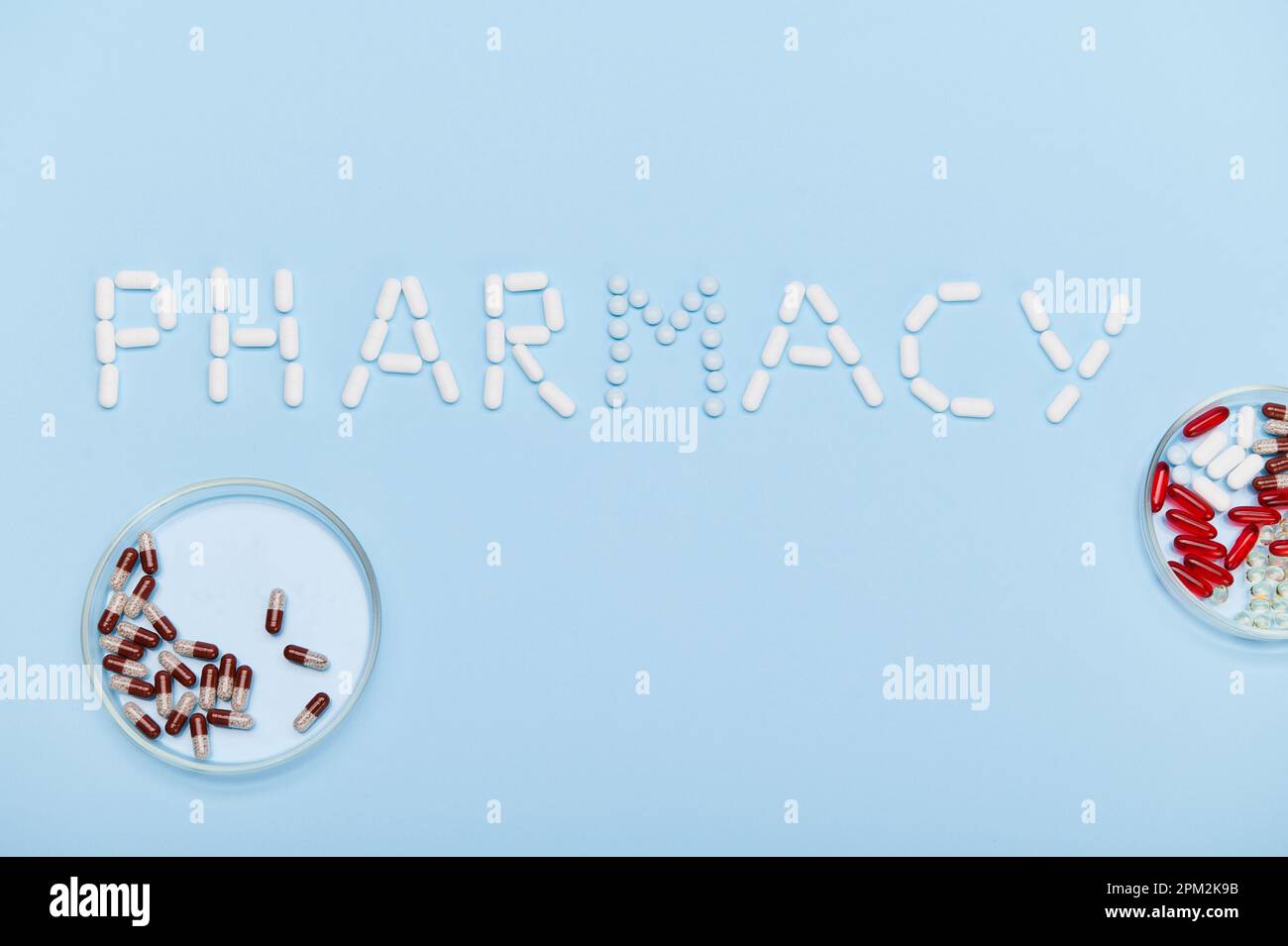 Word PHARMACY laid out with medical therapeutic pills and dragees near ...