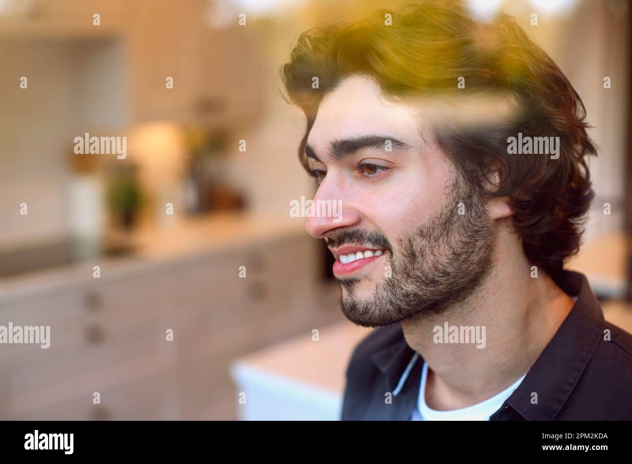 Smiling Young Man At Home In Kitchen Looking Out Through Window Stock ...