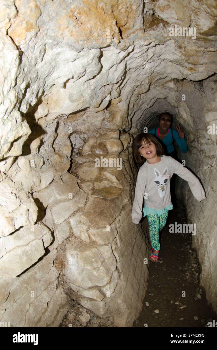 Girl and mother in passageway, Aranui Cave, Otorohanga, Waitomo, North ...