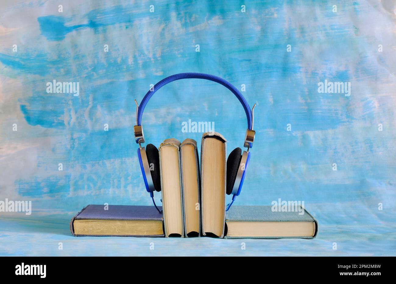 audio book concept with books and vintage blue headphone on blue ...