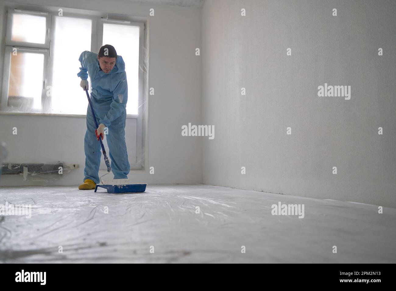 Man paints the ceiling with a roller. Concept of home makeover and ...