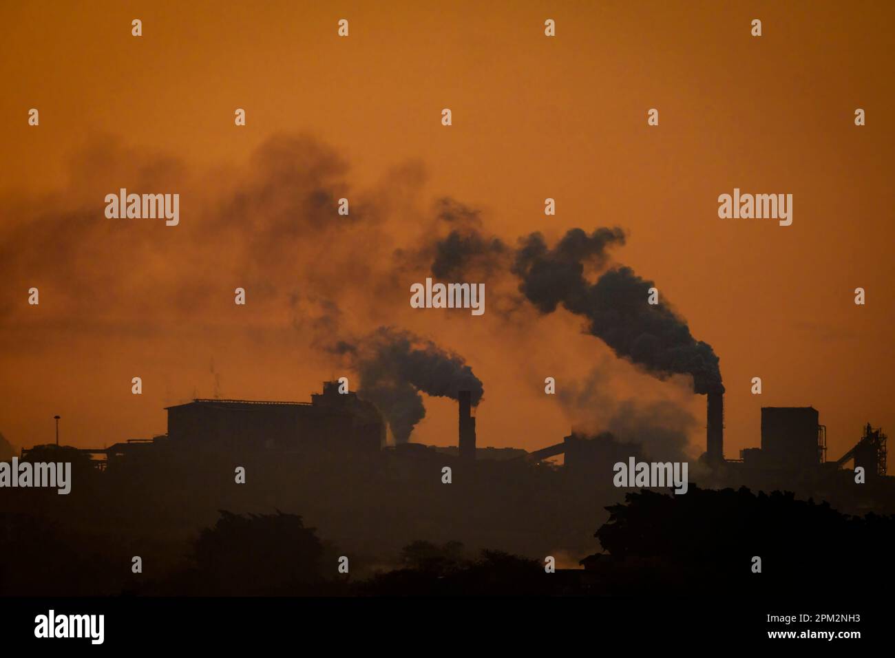 Factory with smoking chimney's at the edge of Kruger national park ...