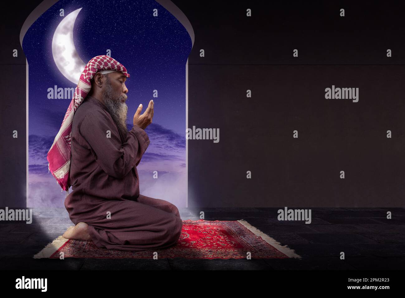 Muslim man with a beard wearing keffiyeh with agal in praying while ...