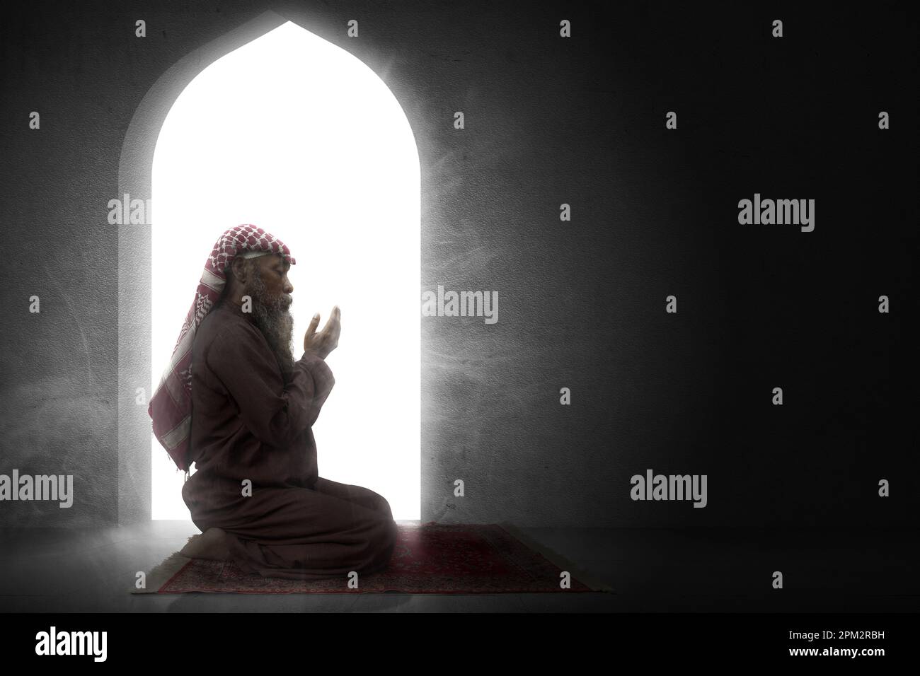 Muslim man with a beard wearing keffiyeh with agal in praying while ...