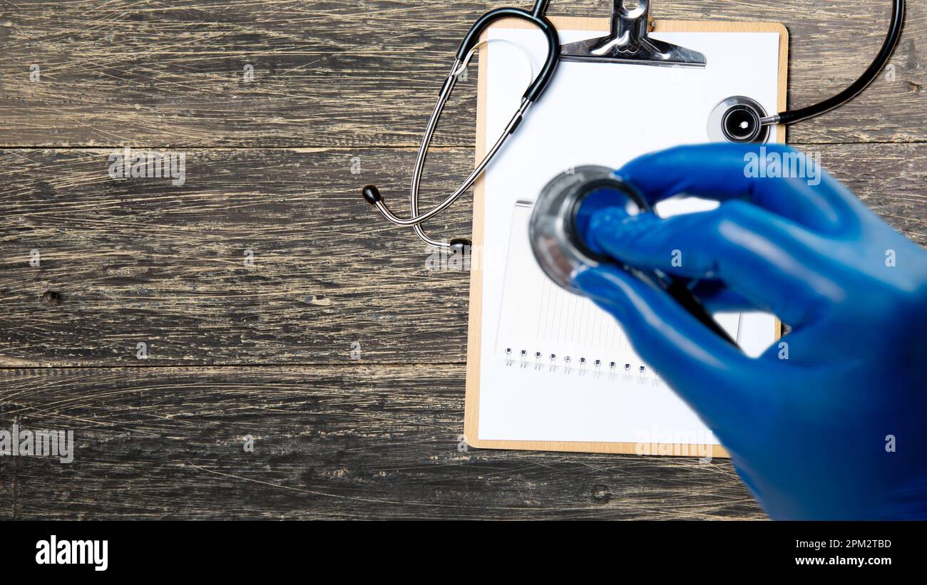 A human hand holding a stethoscope and an empty notebook. World ...