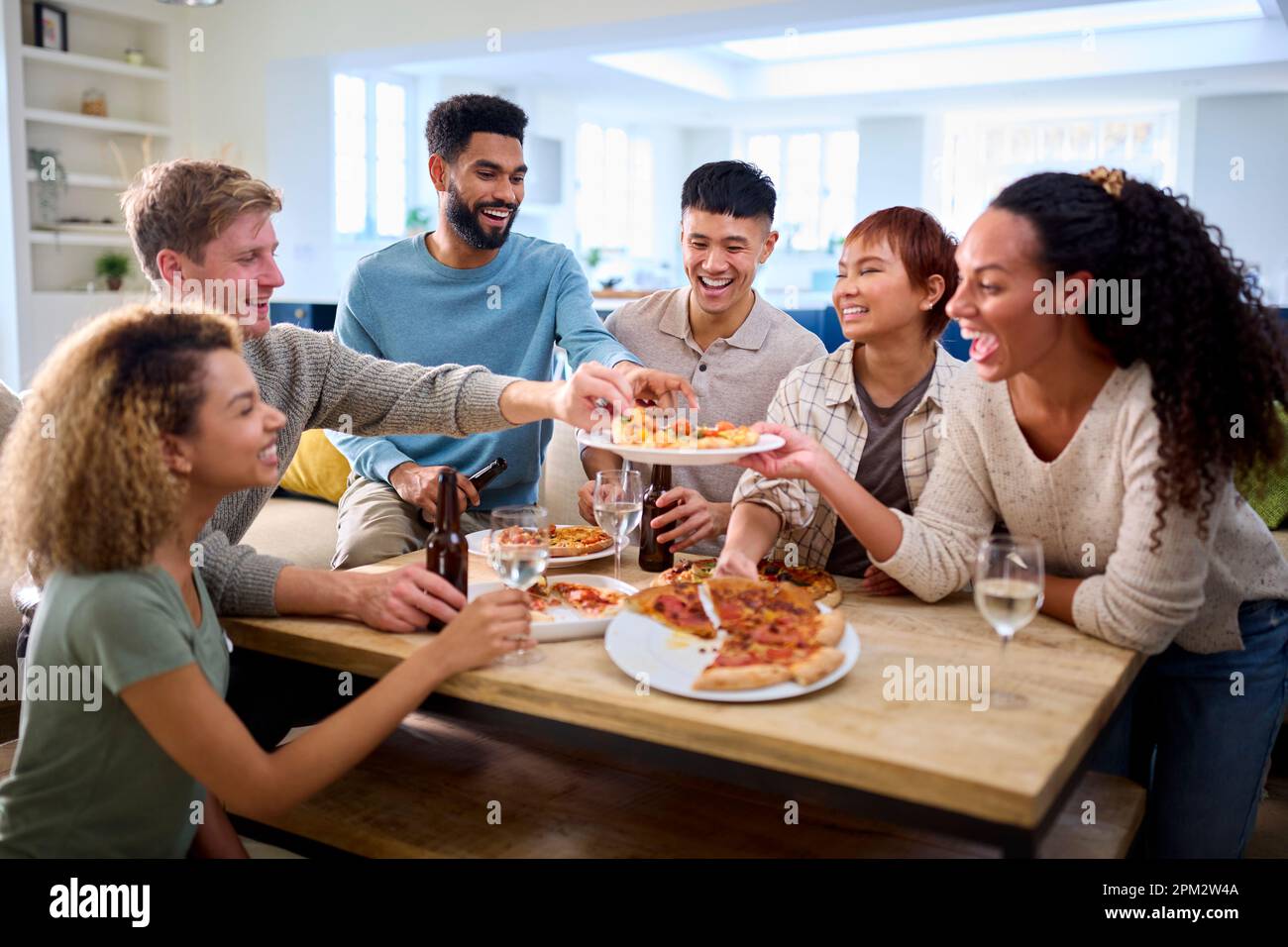 Friends Having Fun At Home In Kitchen Eating Homemade Pizzas Stock ...