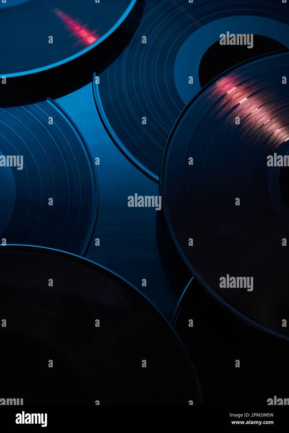 An artsy shot of vintage vinyl records illuminated by a soft blue light ...