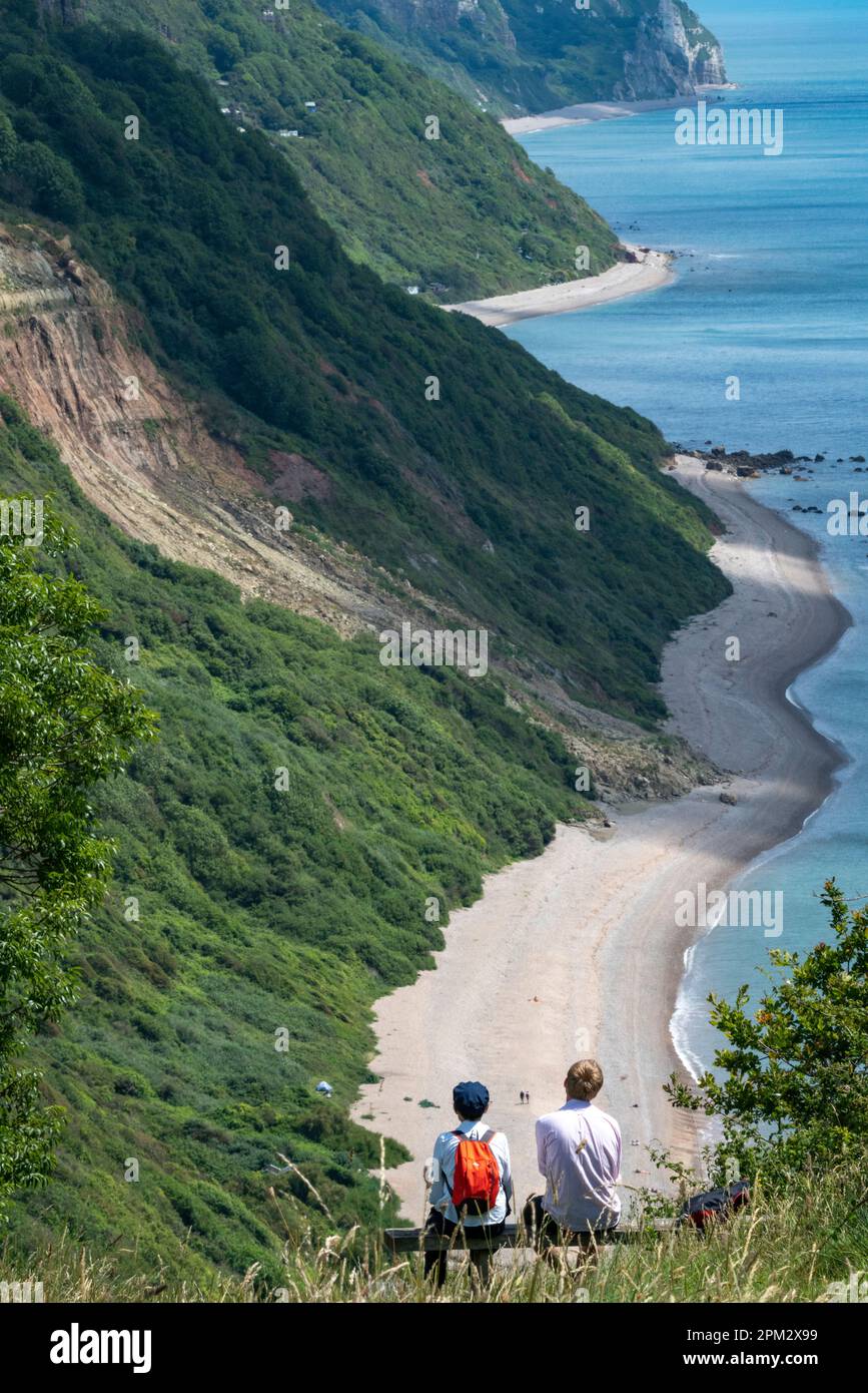 Walkers take in the view of the Coastal walk along the Jurassic Coast between Sidmouth and Beer ...