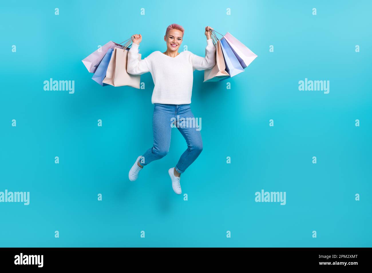 Full body length photo of jumping up careless girl hands up hold bags ...