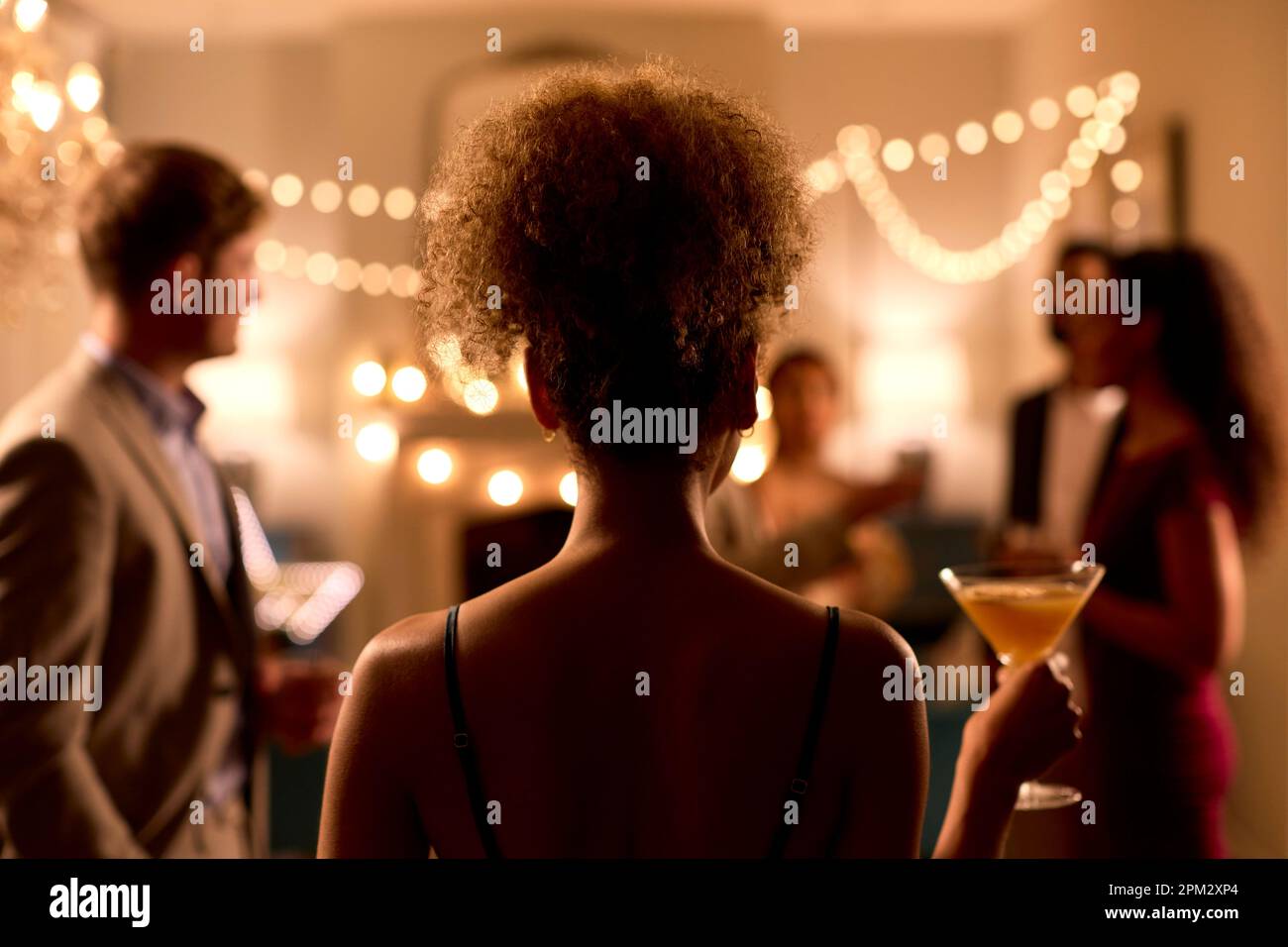 Rear View Of Woman At Party Talking To Guest And Drinking Cocktail ...