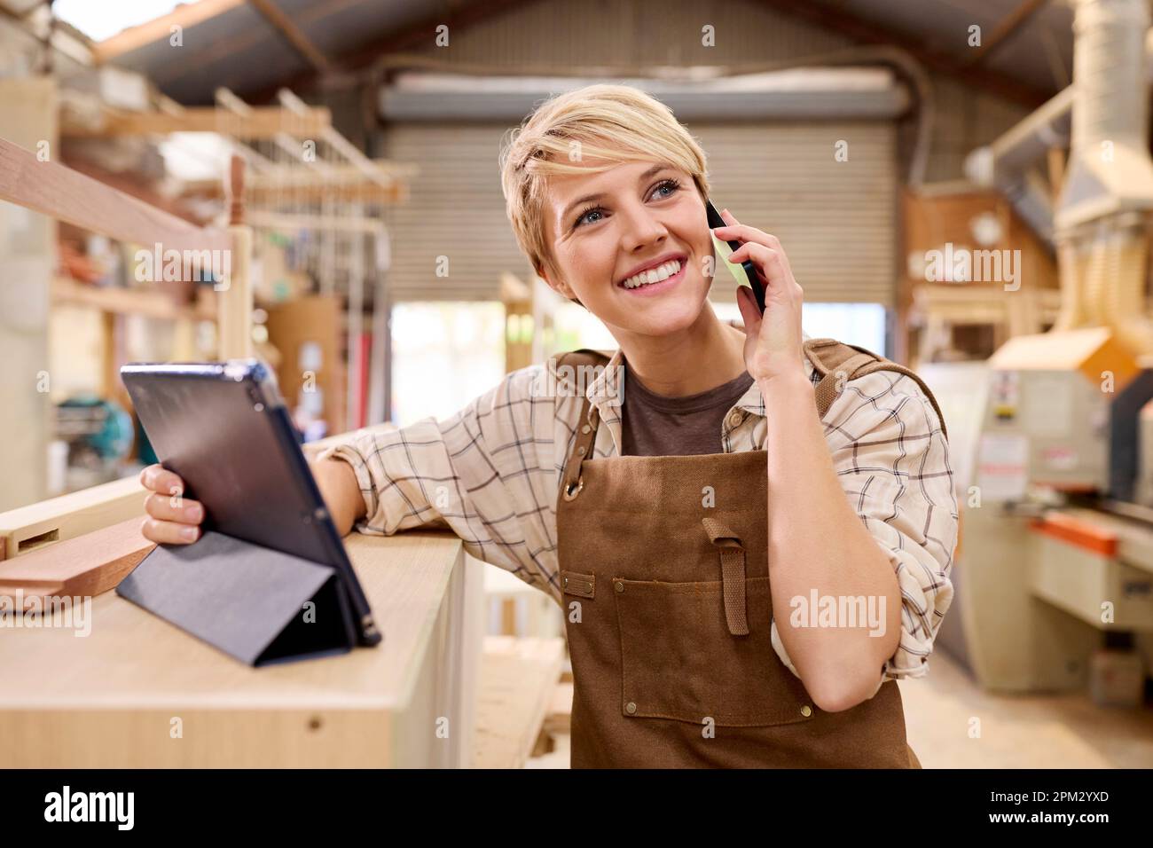 Female Apprentice With Digital Tablet Working As Carpenter In Furniture ...