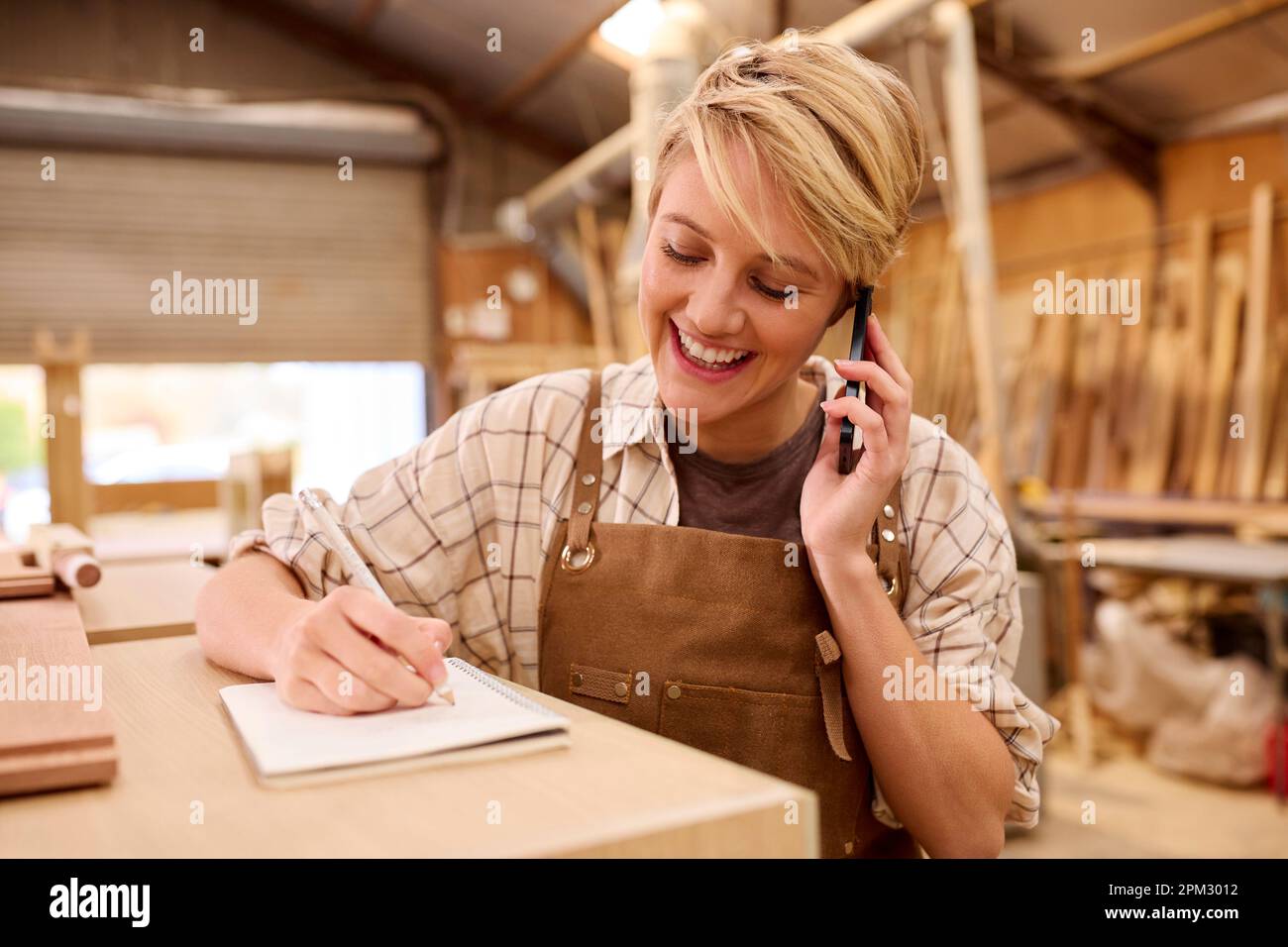 Female Apprentice Working As Carpenter In Furniture Workshop Making ...