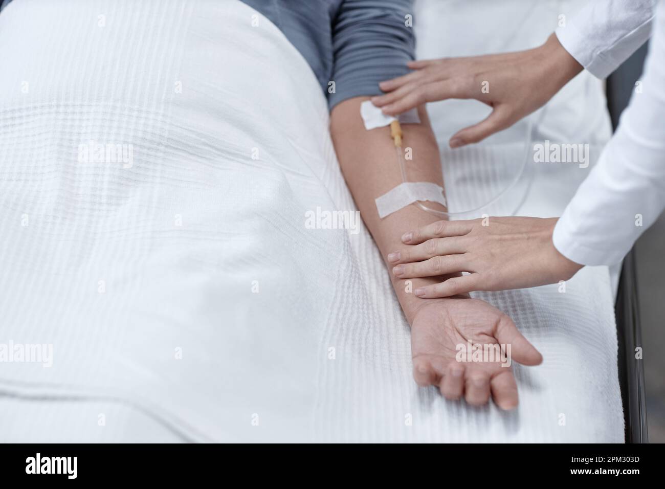 Close-up of nurse making iv drip for senior patient during treatment in ...