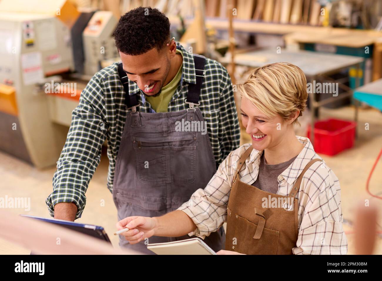Male And Female Apprentices With Digital Tablet Working As Carpenters ...