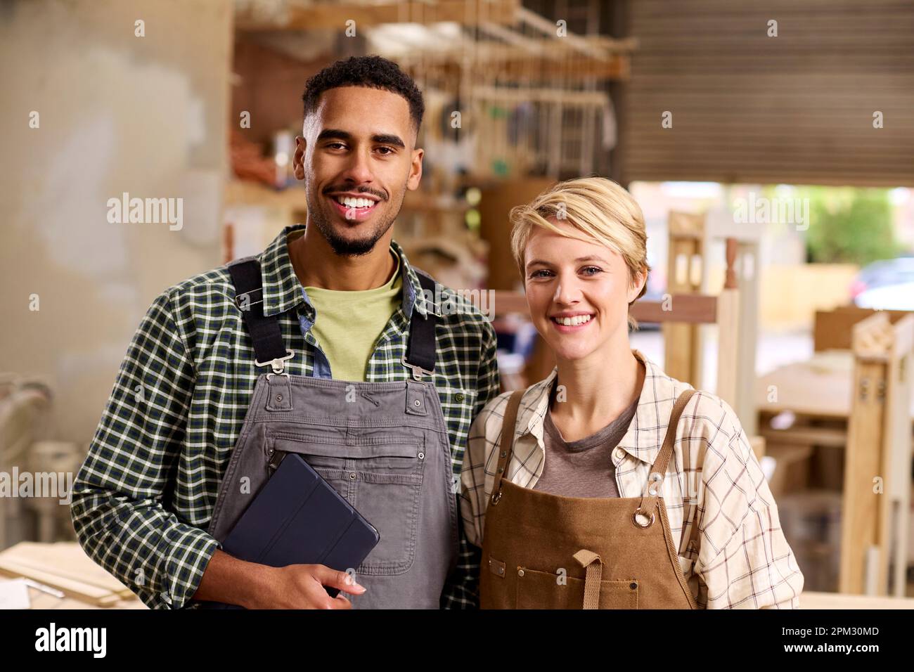 Portrait Of Male And Female Apprentices Working As Carpenters In ...