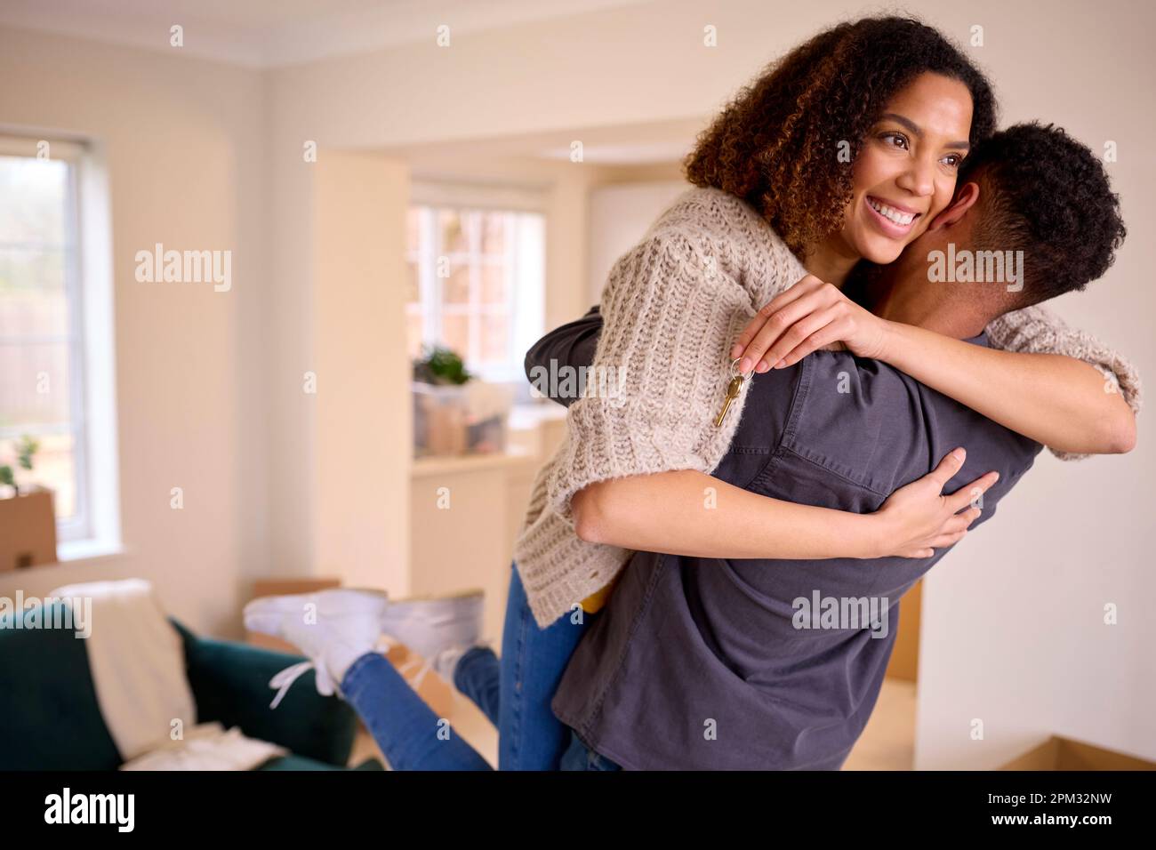 Excited Couple Hugging As They Unpack Boxes In New Home On Moving Day ...