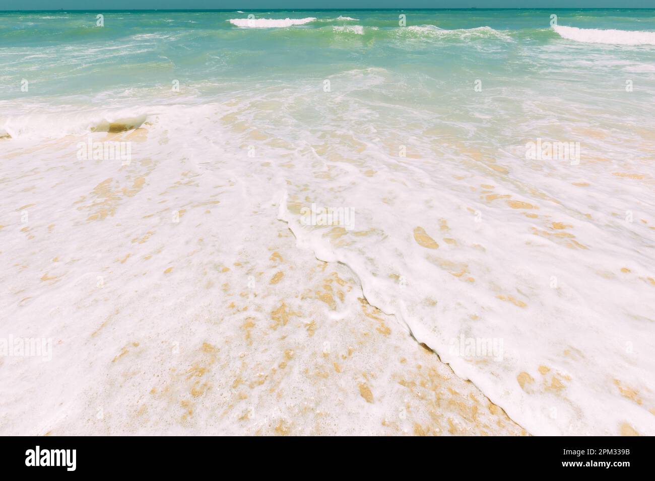 Ocean water foam splashes washing sandy beach. Amazing landscape ...
