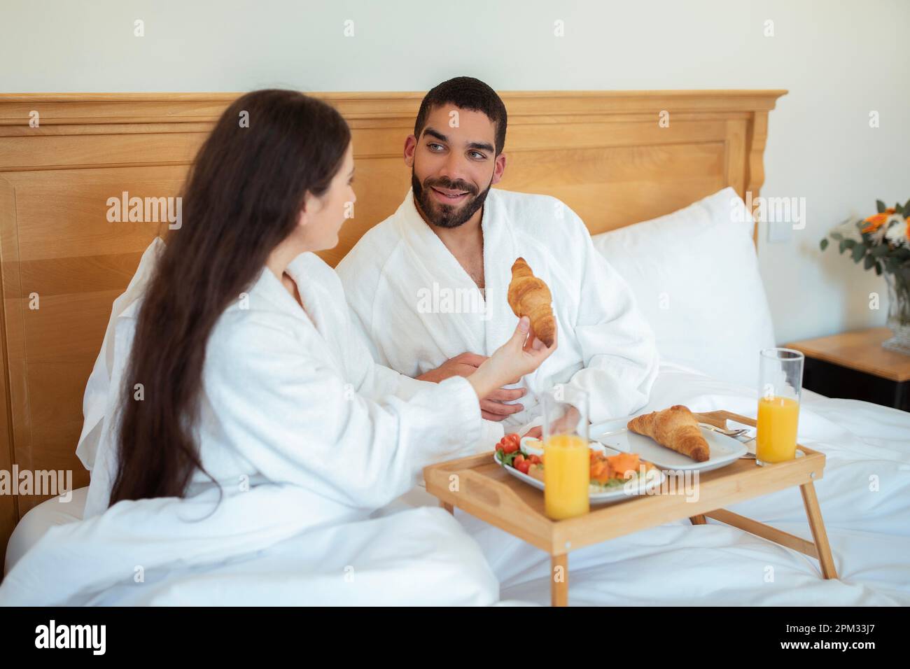 Multicultural Couple Having Romantic Breakfast In Bed Eating Croissants ...