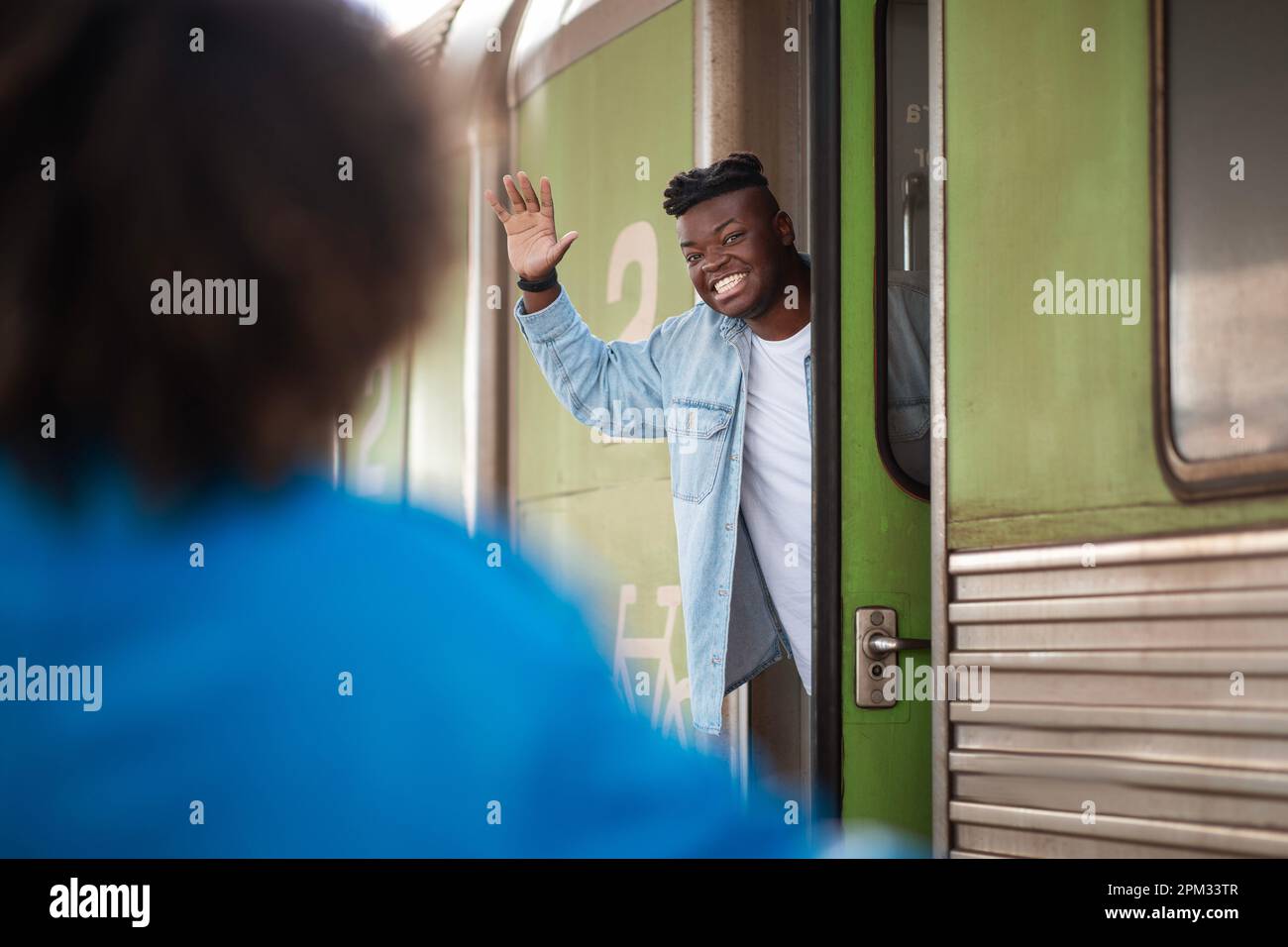 Cheerful Black Man Waving Hand To Girlfriend While Standing In Train ...