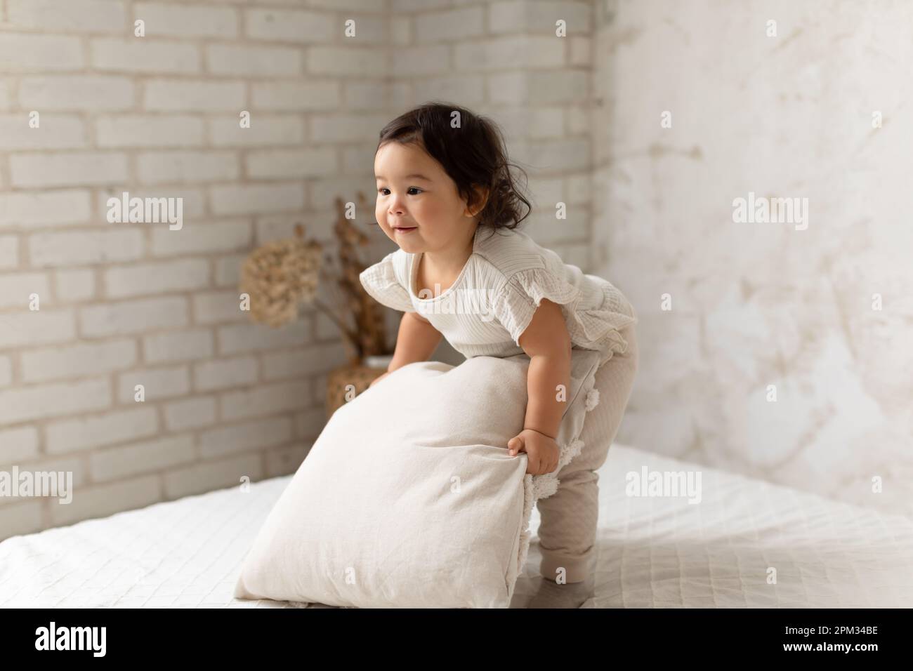 Cute Japanese Little Baby Girl Holding Pillow Playing In Bedroom Stock ...