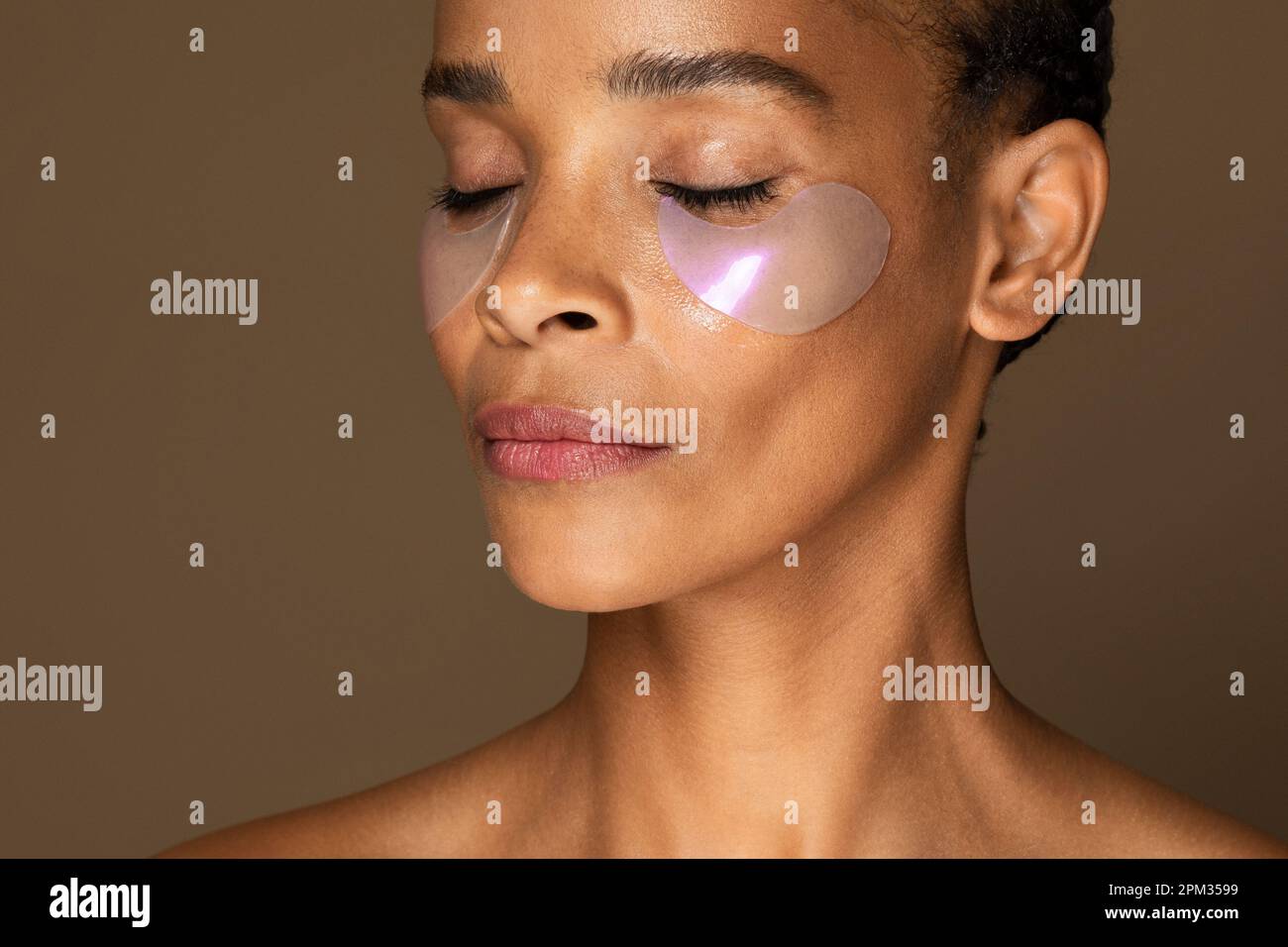 Facial skincare. Black middle aged woman with applied cosmetic patches ...