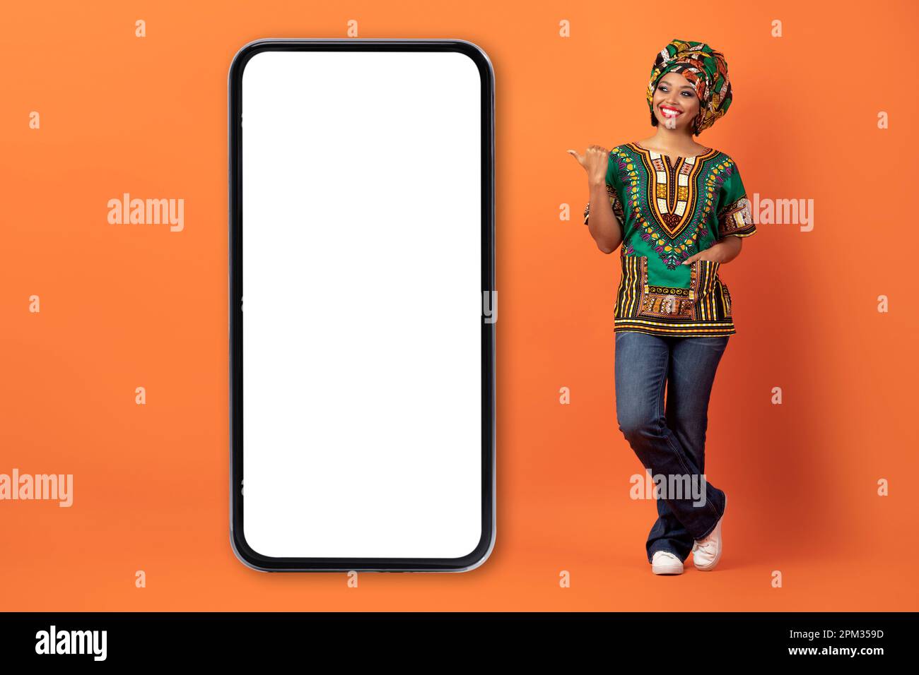 Cool african lady pointing at huge phone with blank screen Stock Photo ...