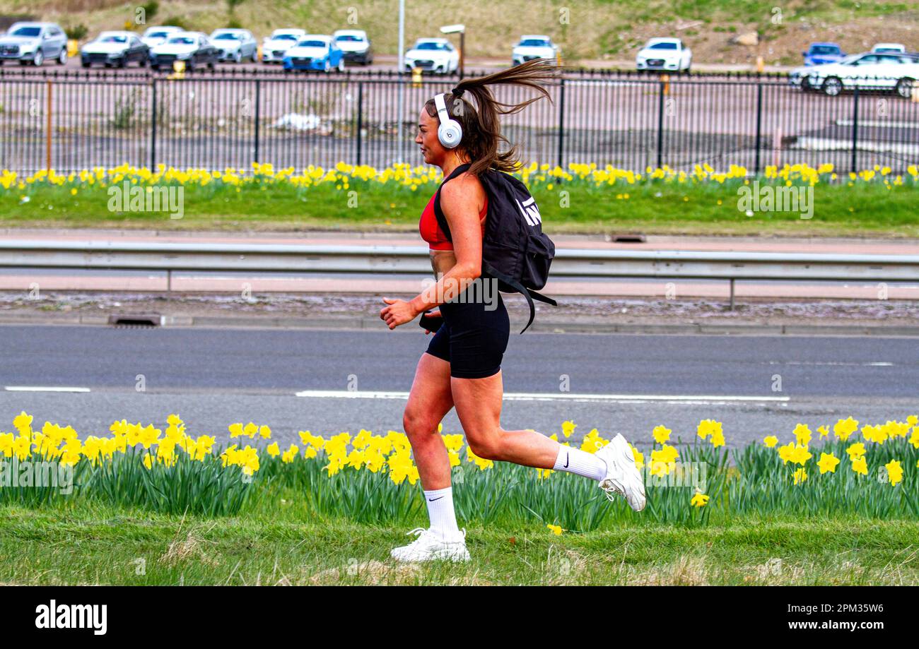 Woman jogging along roadside hi-res stock photography and images - Alamy