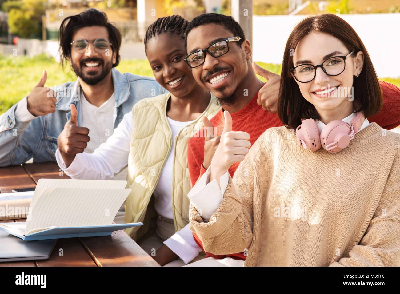 Glad friendly millennial multiethnic modern students read books, study ...