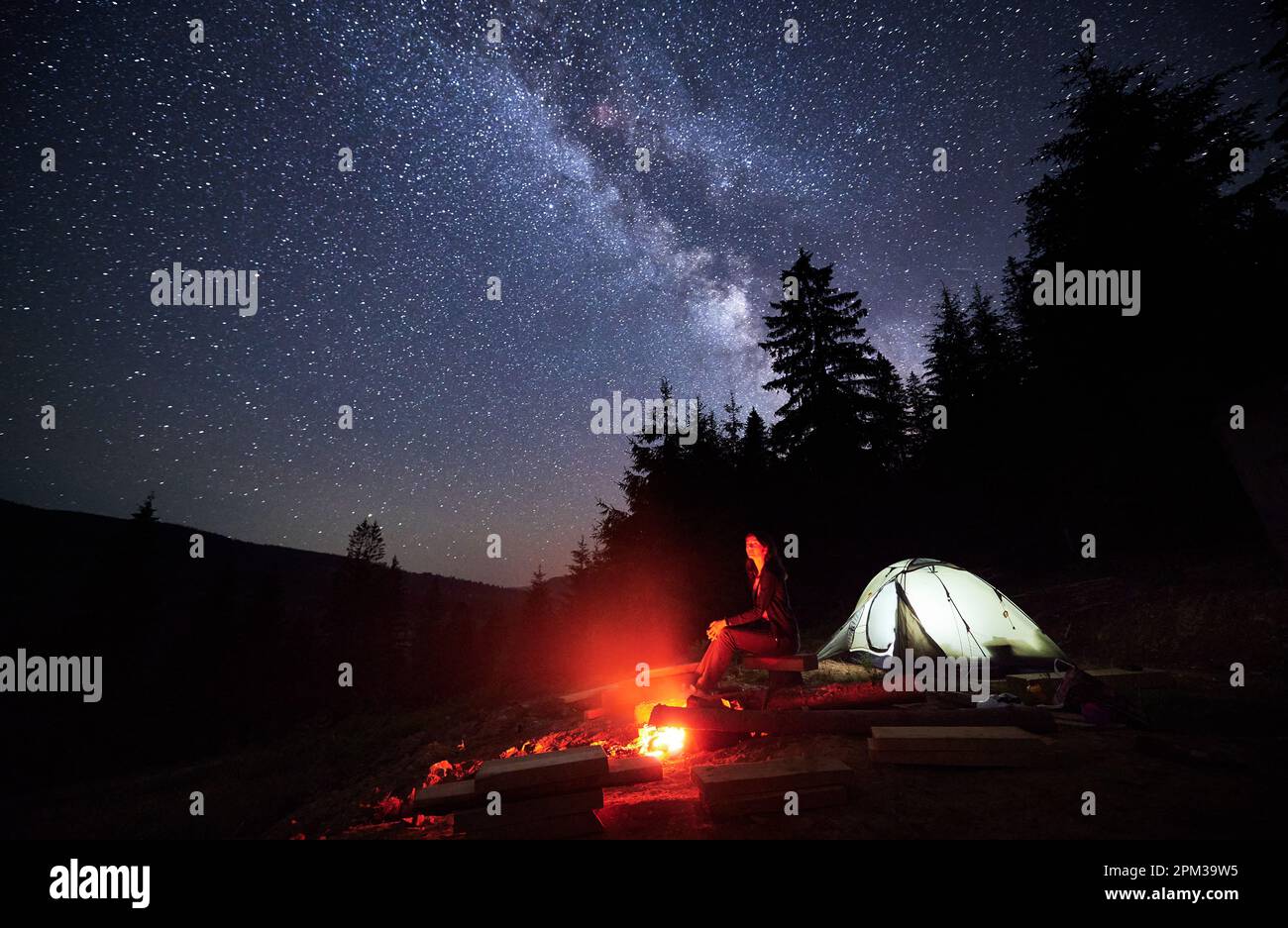 Night-time camping excursion in mountains, amidst twinkling stars ...