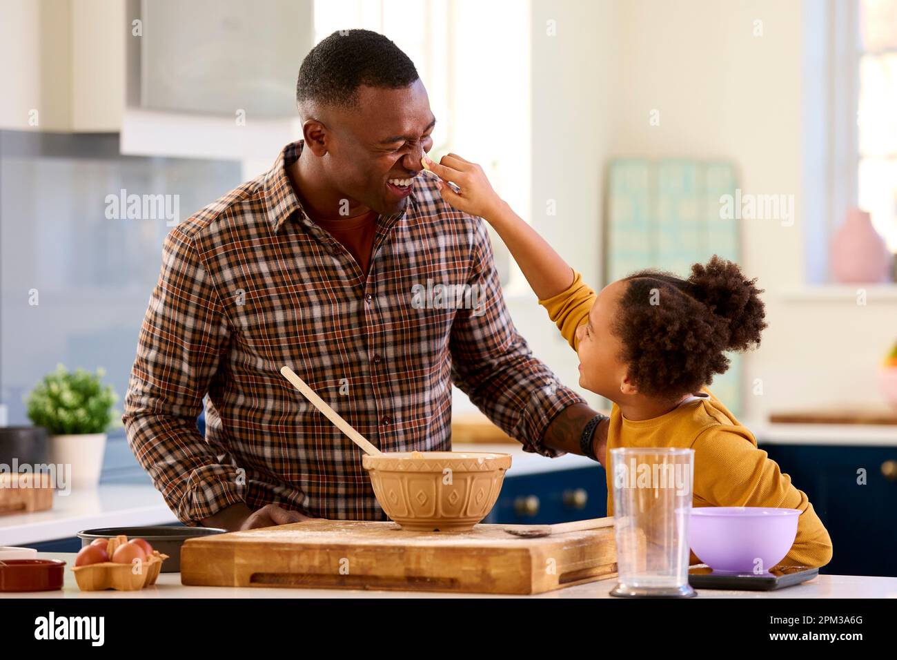 Family Shot With Father And Daughter Having Messy Fun Baking At Home In ...