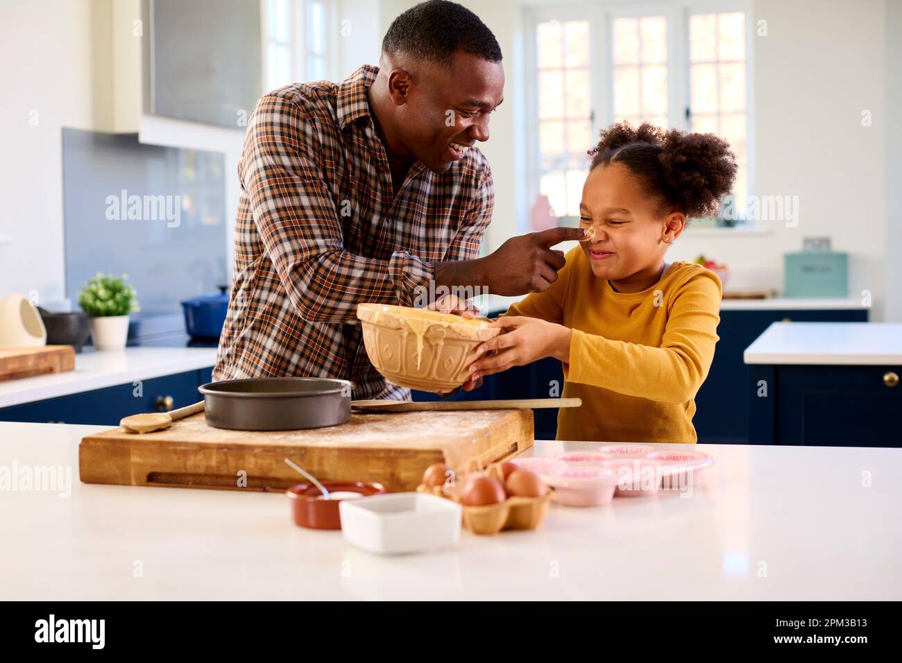 Family Shot With Father And Daughter Having Messy Fun Baking At Home In ...