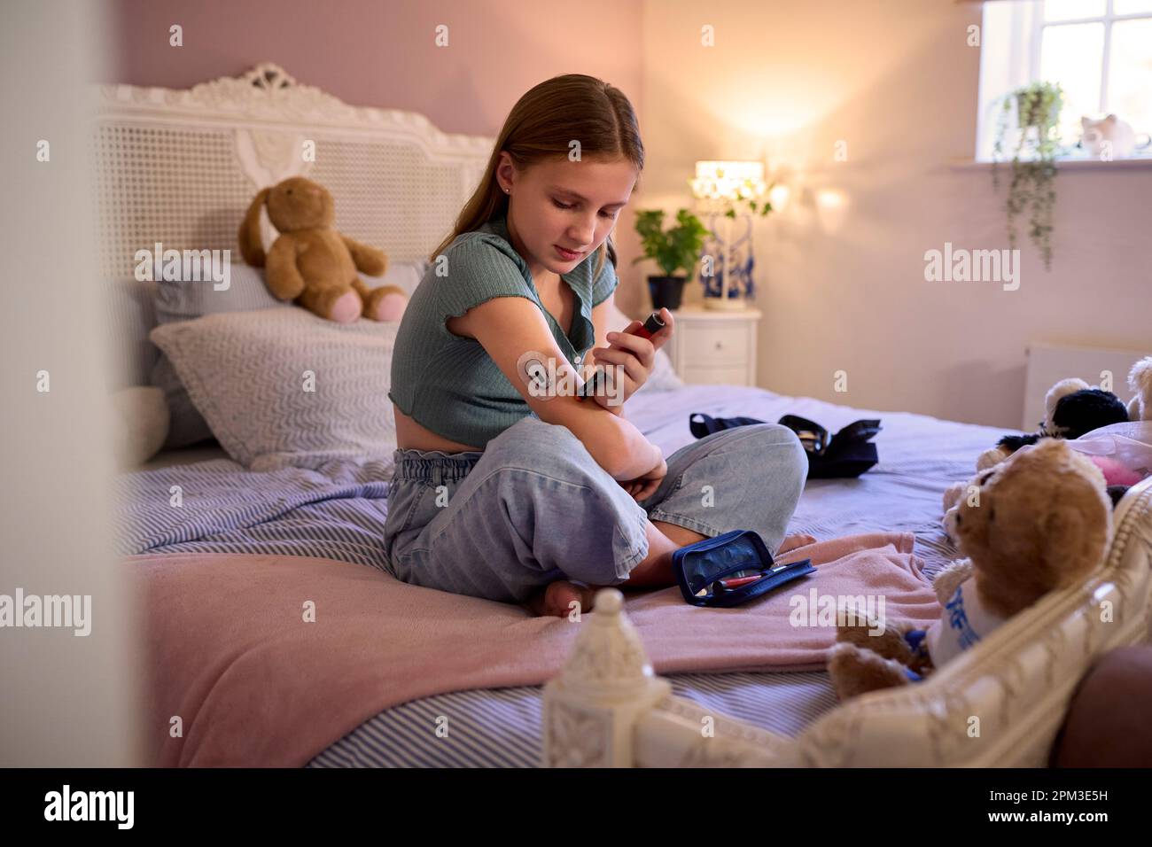 Young Diabetic Girl Sitting On Bed In Bedroom At Home Using Kit To ...