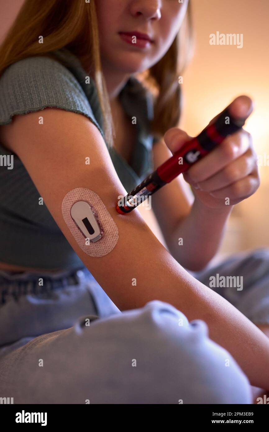 Close Up Of Young Diabetic Girl Sitting On Bed In Bedroom At Home Using ...
