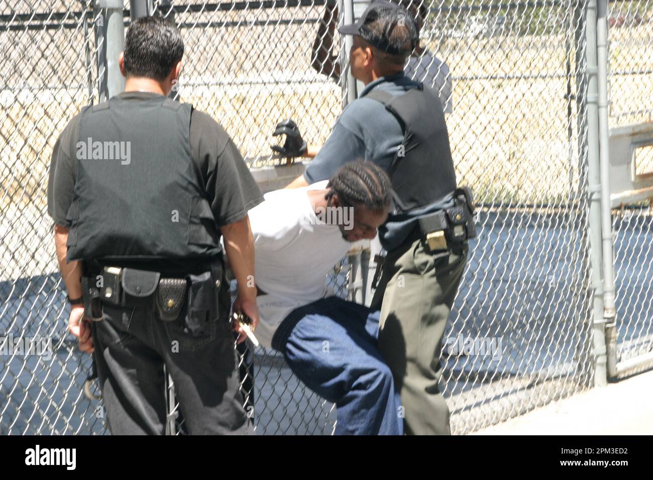 A group of law enforcement professionals are assisting a detainee in ...