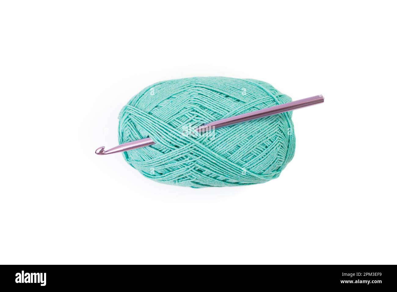 green thread spool with purple crochet hook, isolated on white ...
