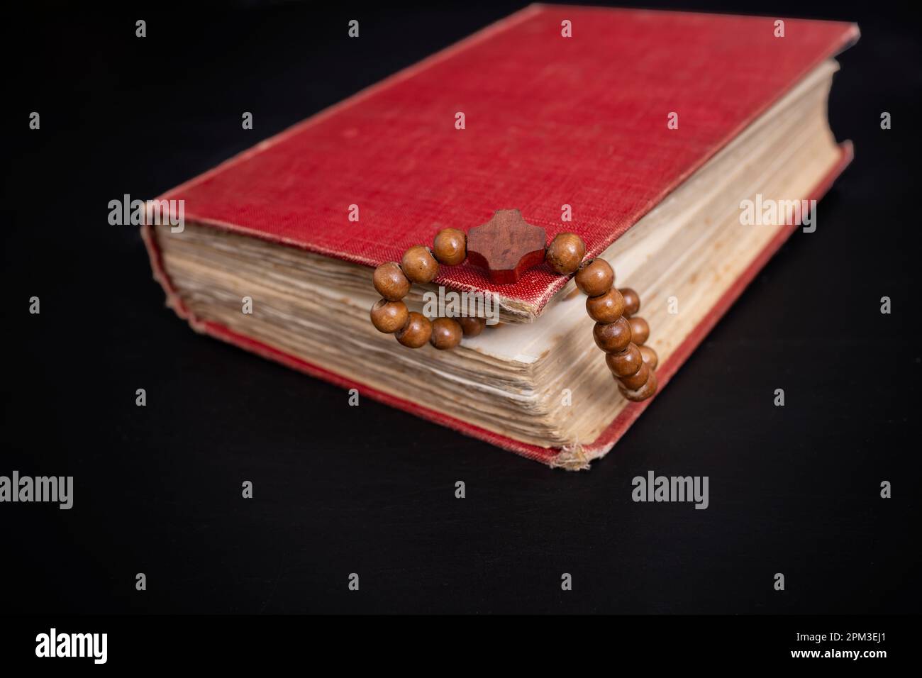 Wooden beads on a string between the pages of a red hard cover book, on ...