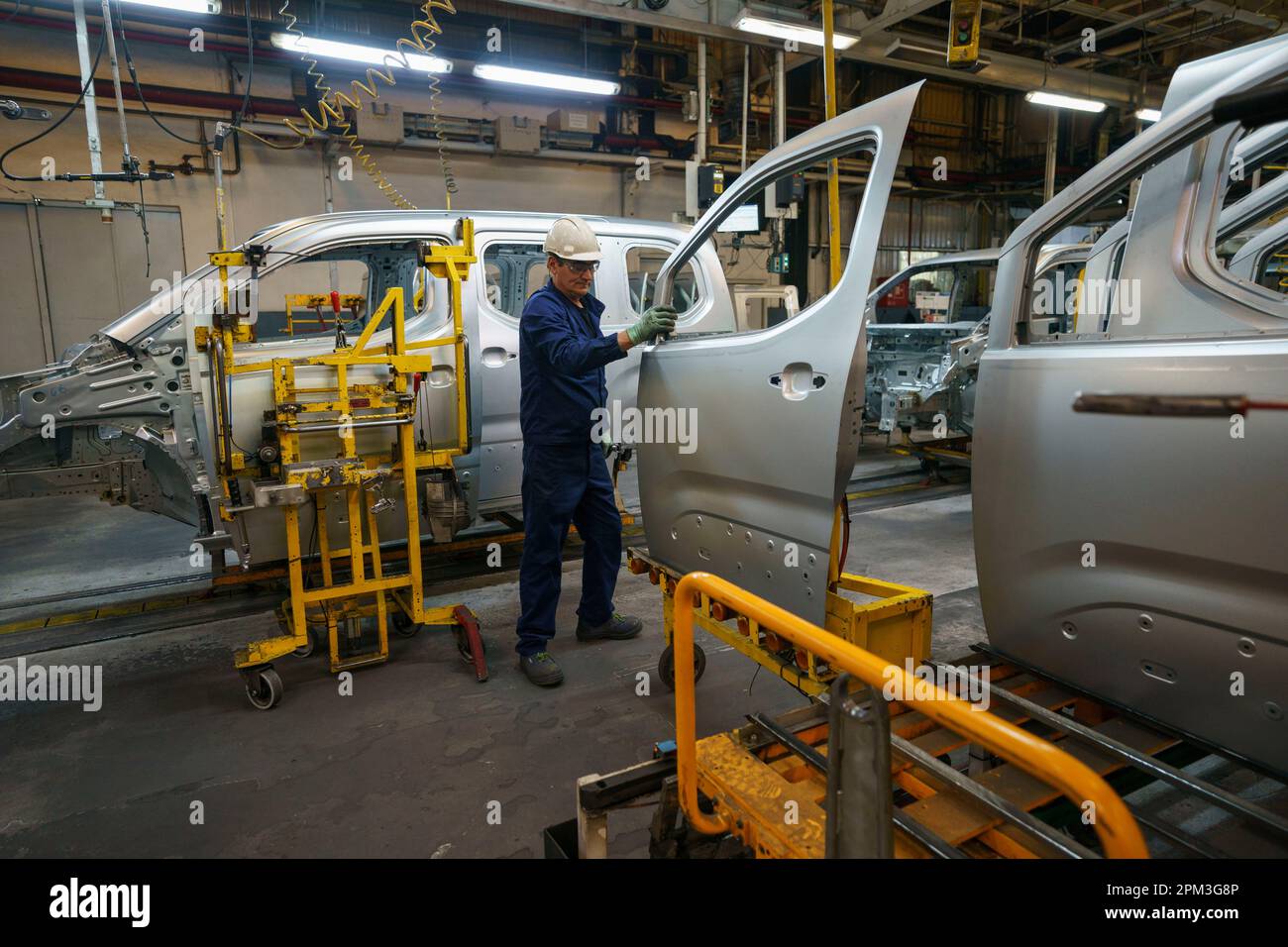 Worker moving a door at a car factory Stock Photo - Alamy