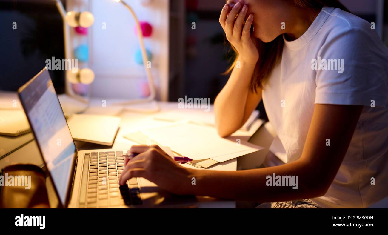 Close Up Of Tired Teenage Girl Yawning Studying At Home With Laptop In ...