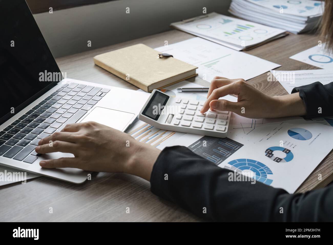 Bookkeeper using a calculator to calculate numbers on a company's ...