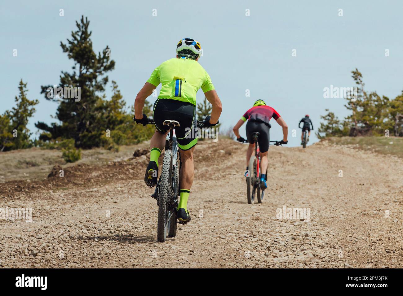 rear view group athlete cyclist riding mountain bike uphill, biking on ...