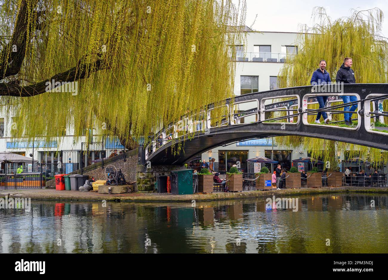 Camden Town, London, UK: Two people on a footbridge crossing Regents ...