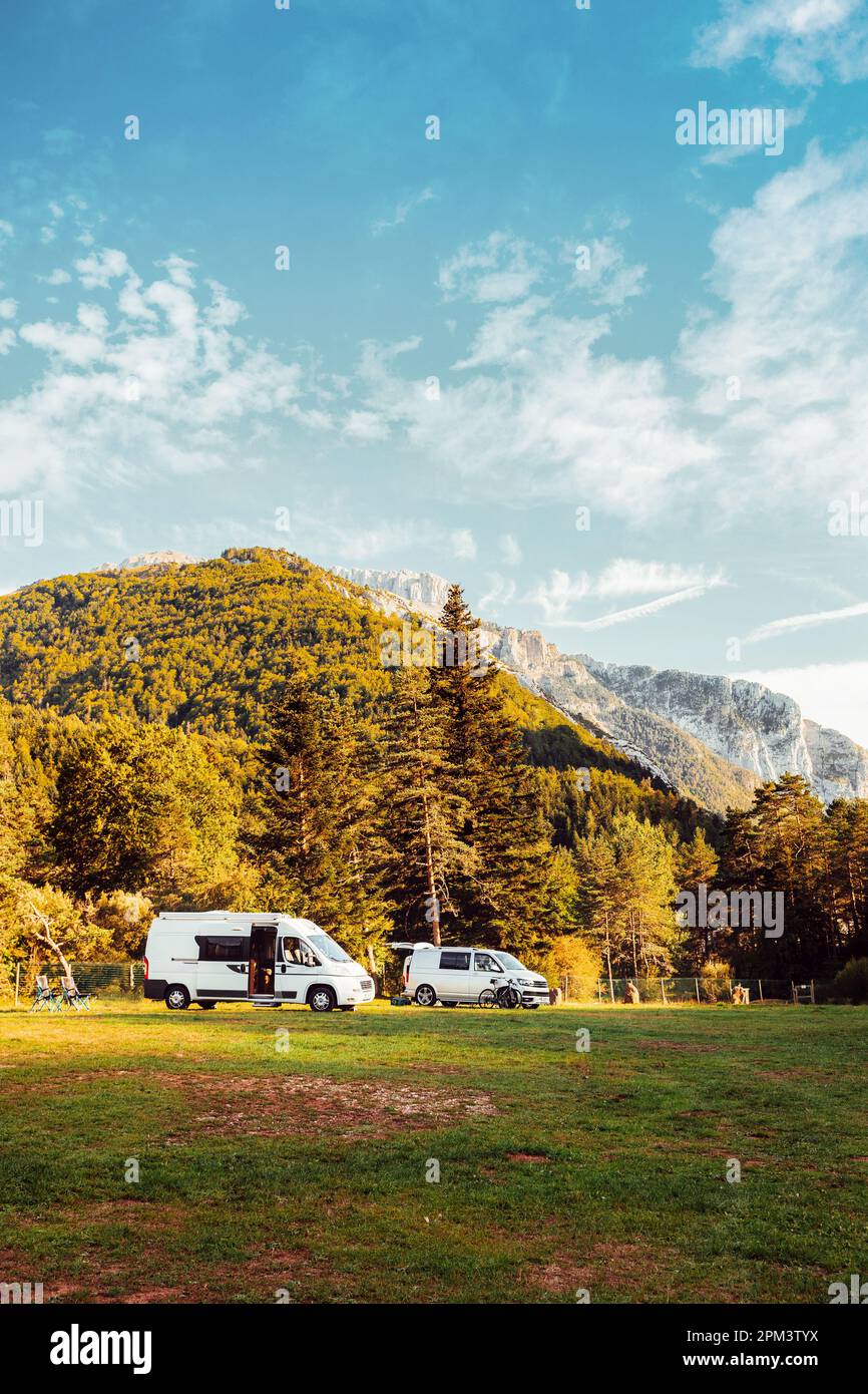 Two camper vans in a camping with amazing landscape views of forest and ...